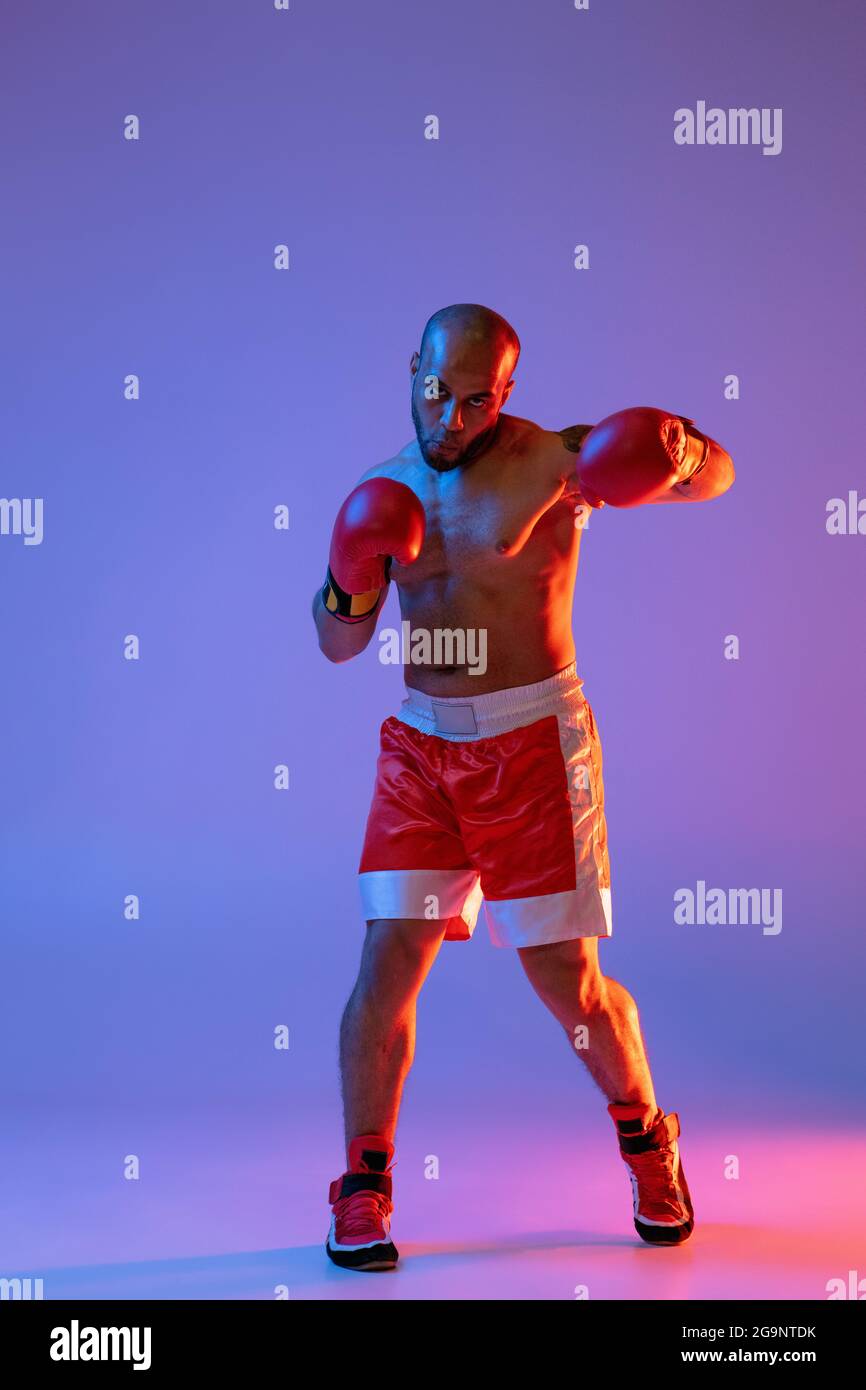Full length portrait of one professional male boxer training ...