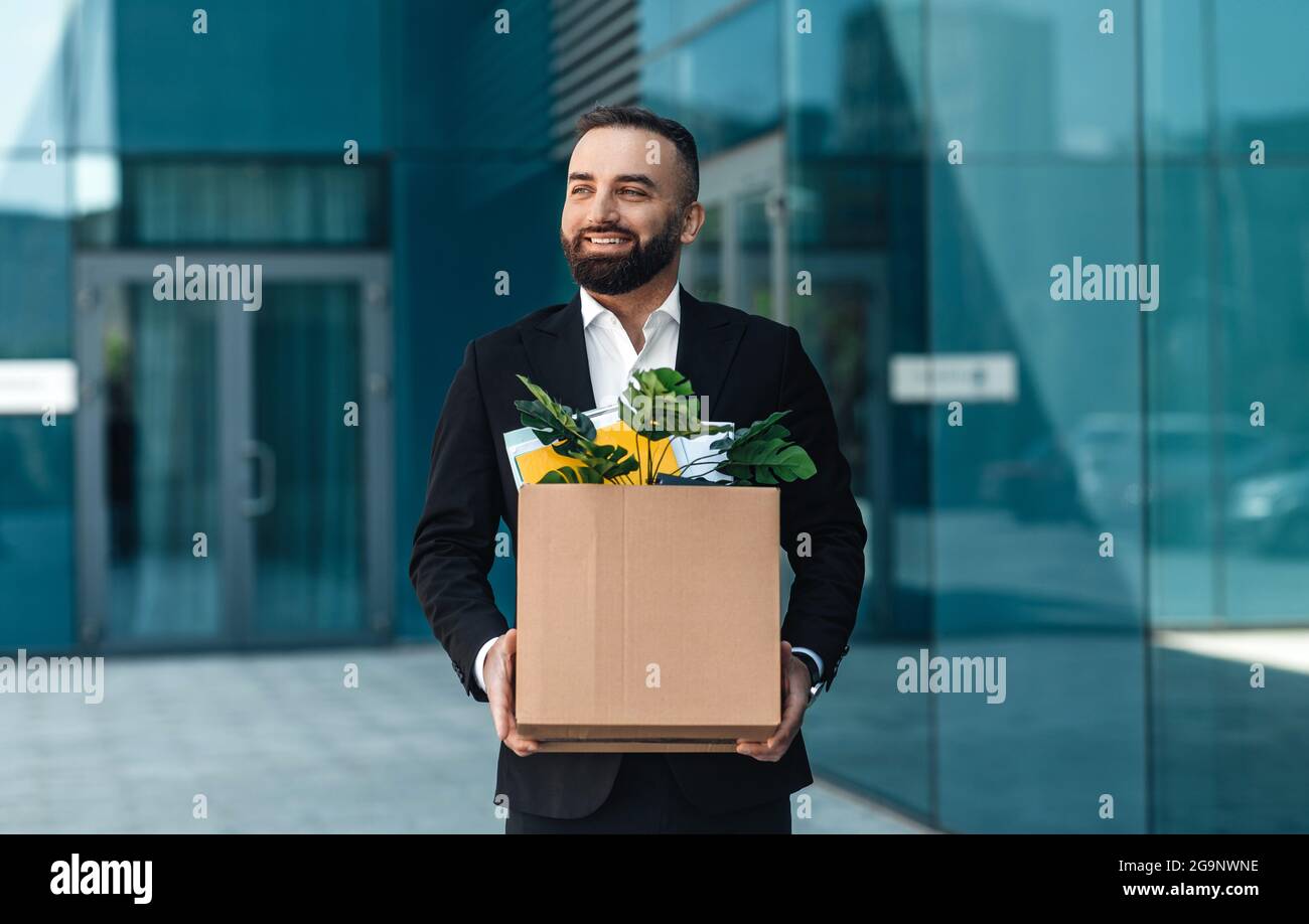 Come back to work after lockdown. Happy businessman with box of ...