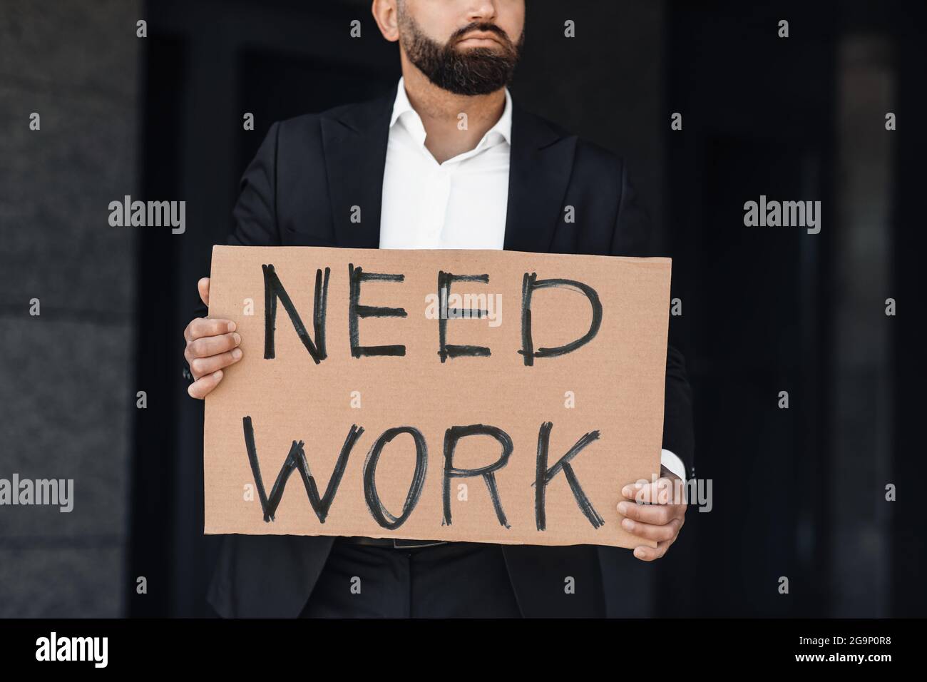 Need work. Unrecognizable male office worker holding cardboard sign ...