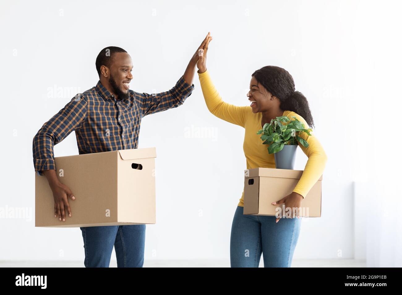 Moving Day. Joyful Black Spouses Holding Cardboard Boxes And Giving ...