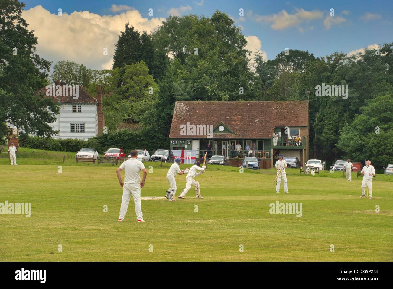 A traditional summer English country scene - cricket on a village green ...