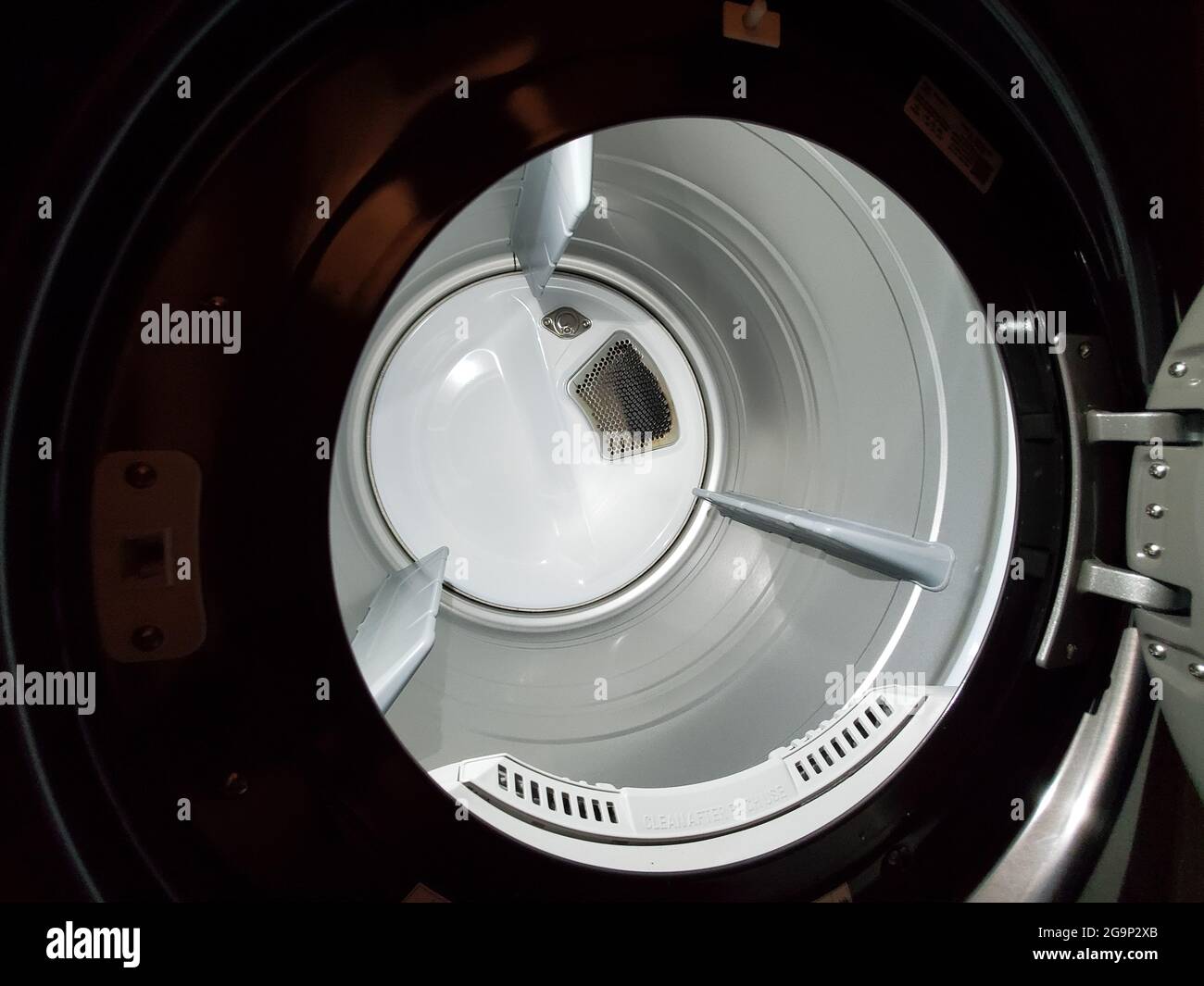 Lighted interior of domestic dryer with air inlet and drum visible ...