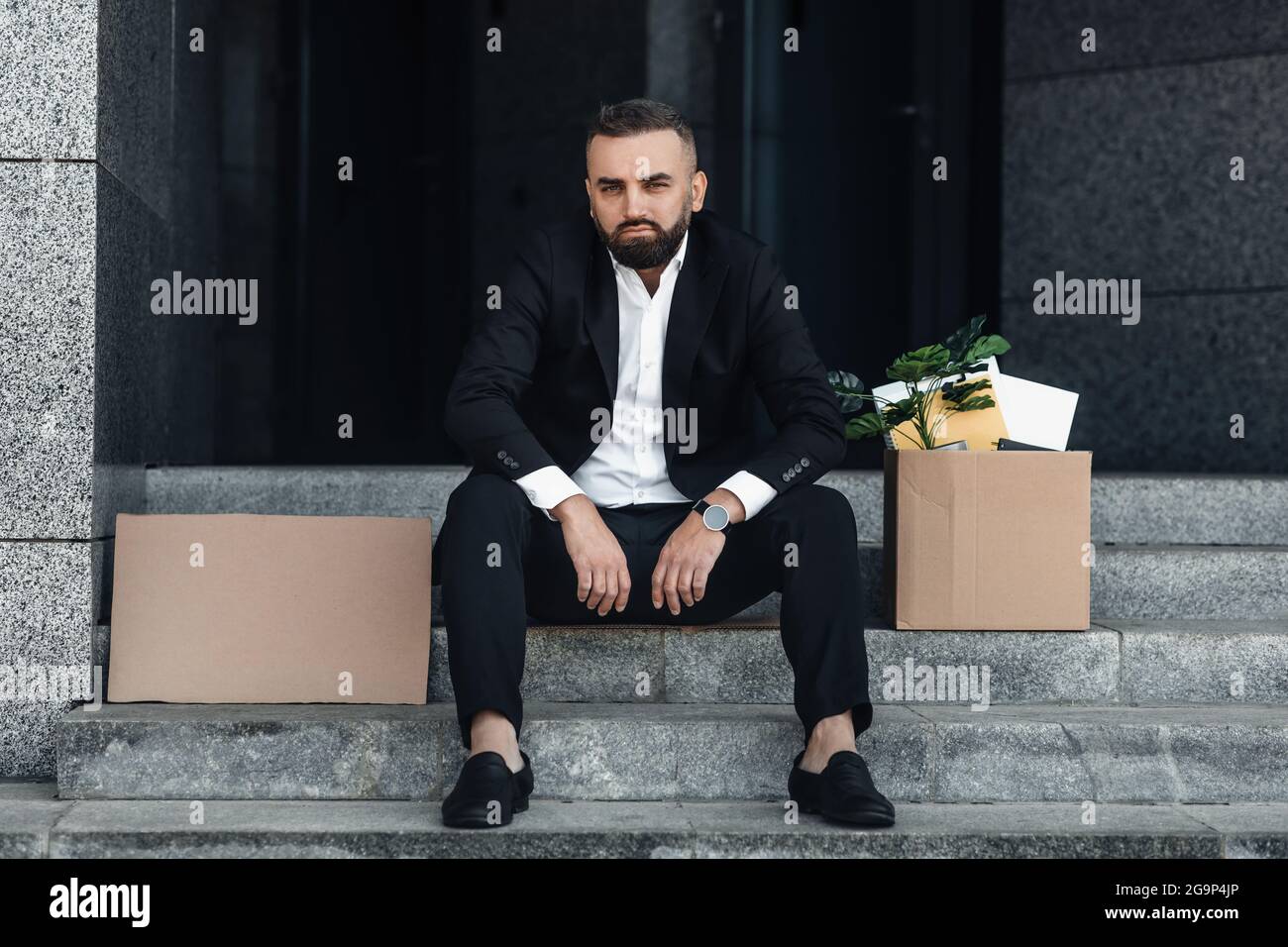 Depressed jobless male office worker with empty cardboard poster and ...