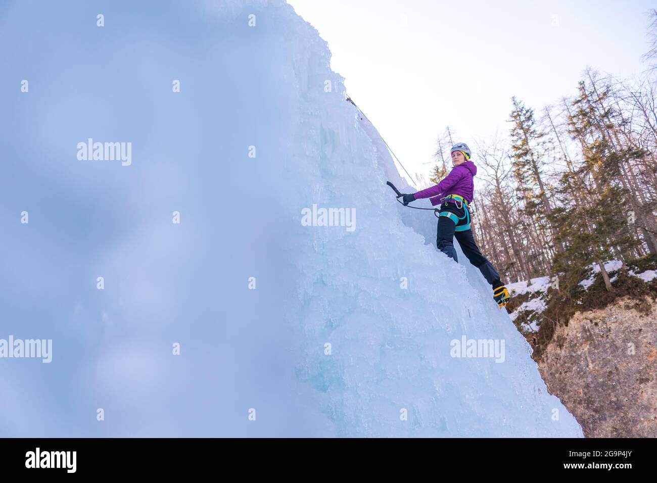 Female ice climber silhouette swinging axes into the ice with force ...