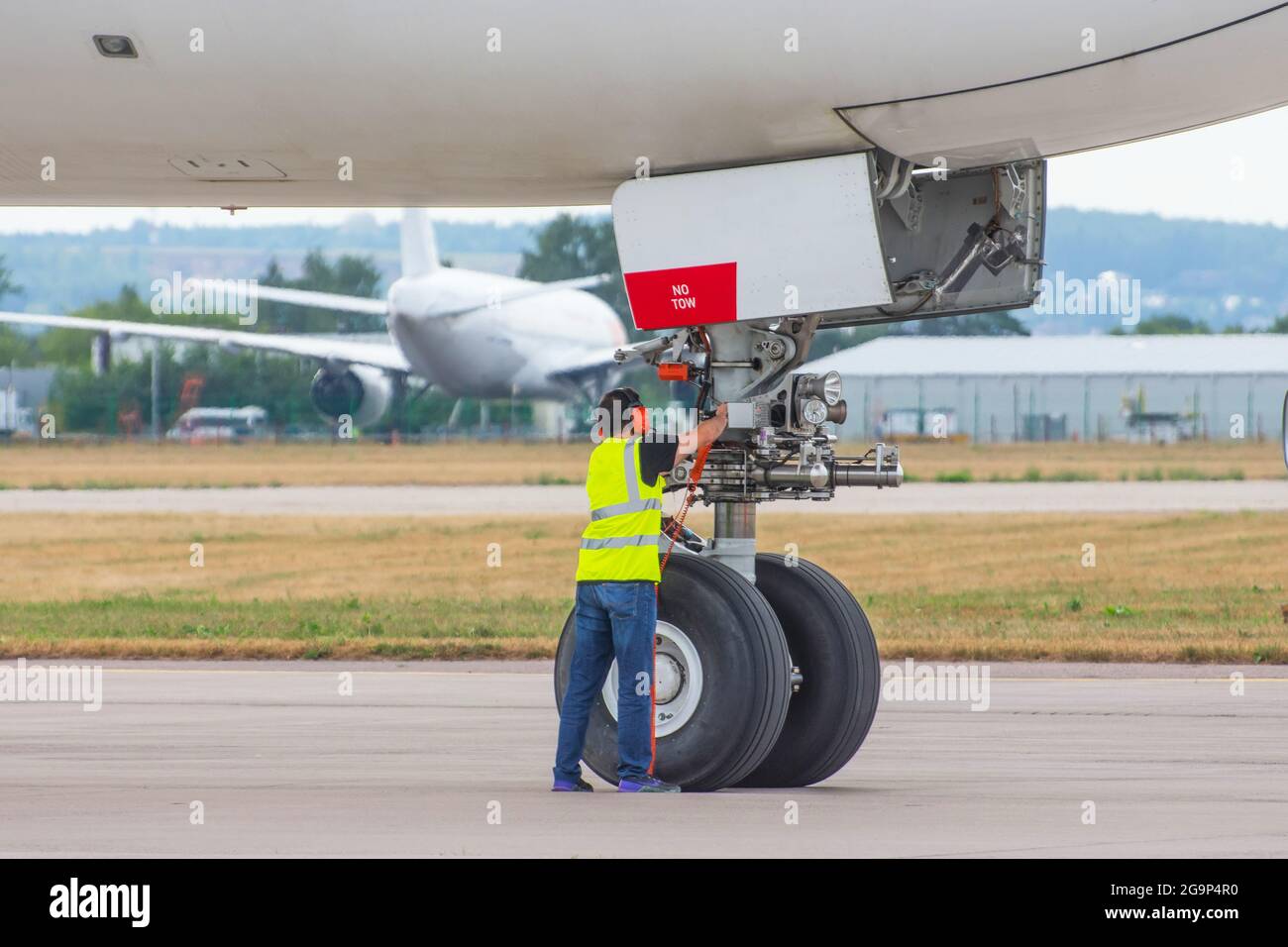 Jet engine aviation technician posing next to a commercial aircraft on ...