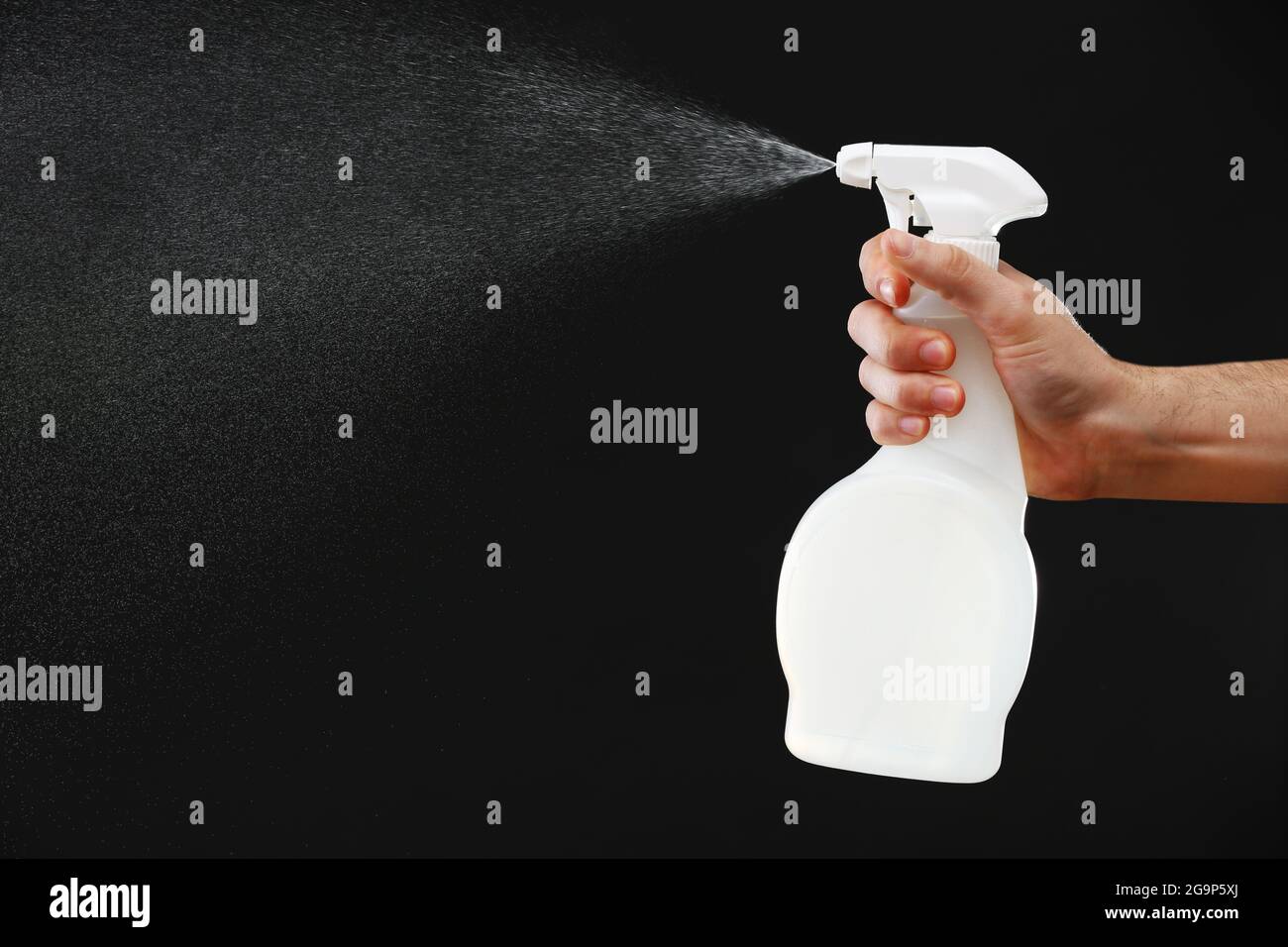Male hand with sprayer on black background Stock Photo - Alamy