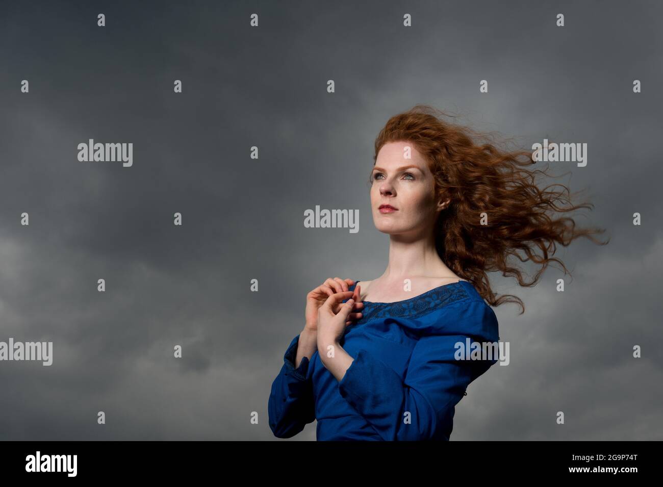 Girl with flowing red hair in windy weather Stock Photo - Alamy