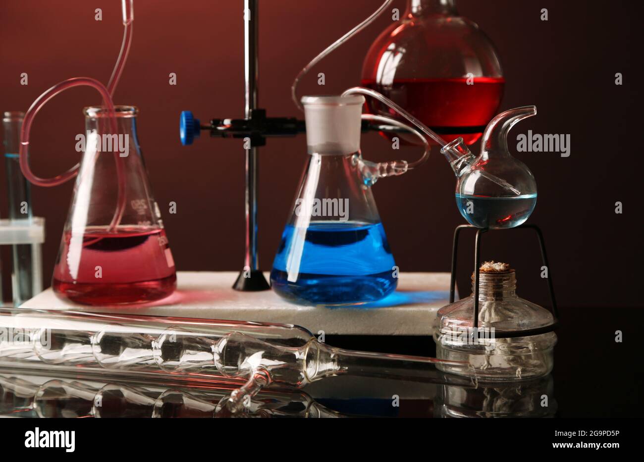 Fixed laboratory glassware on support on dark colorful background Stock ...
