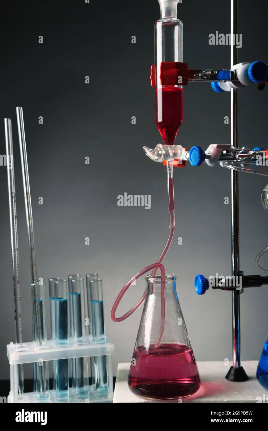 Fixed laboratory glassware on support on dark colorful background Stock ...