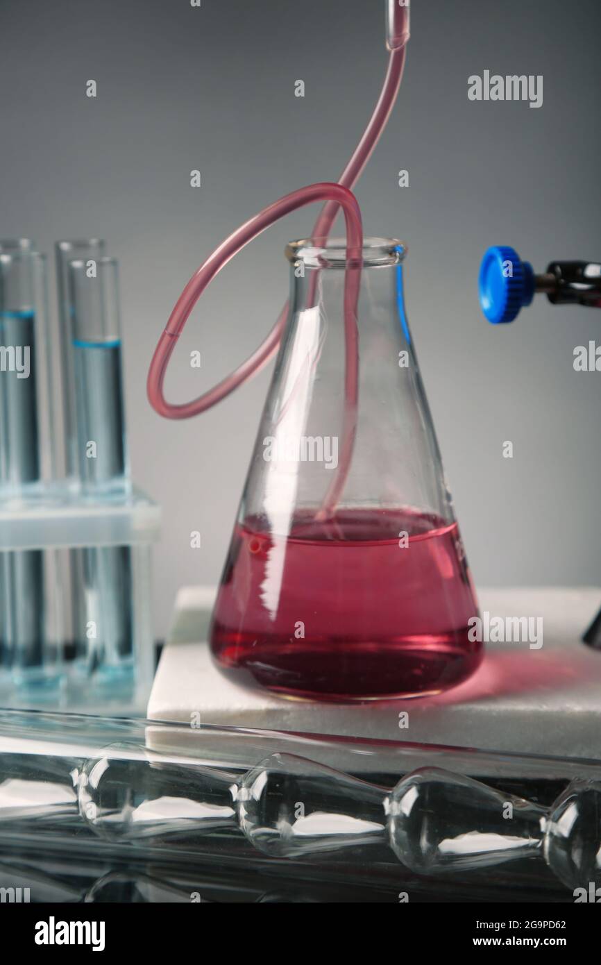 Fixed laboratory glassware on support on dark colorful background Stock ...