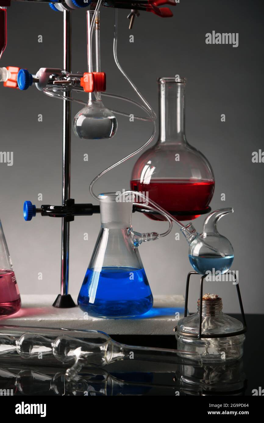 Fixed laboratory glassware on support on dark colorful background Stock ...