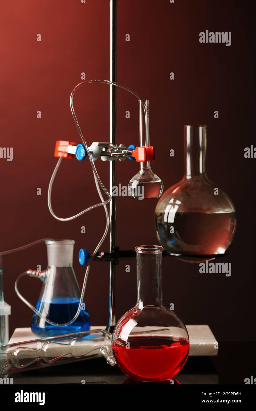 Fixed laboratory glassware on support on dark colorful background Stock ...