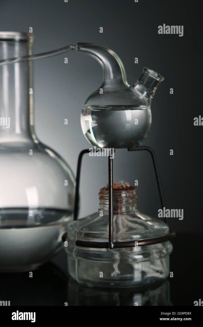 Fixed laboratory glassware on dark background Stock Photo - Alamy