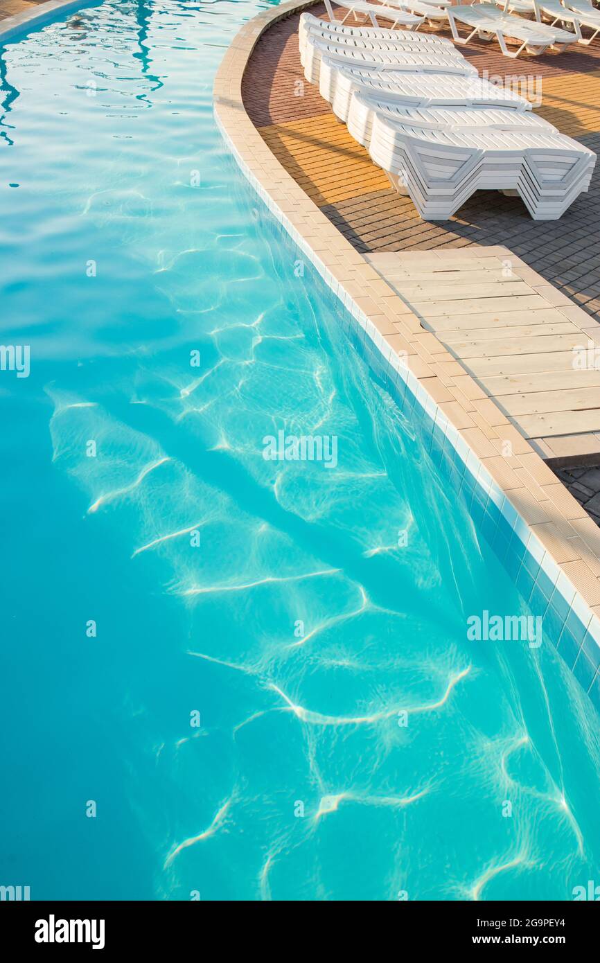 Luxury spa poolside with lounges in light of sunset, during summertime ...
