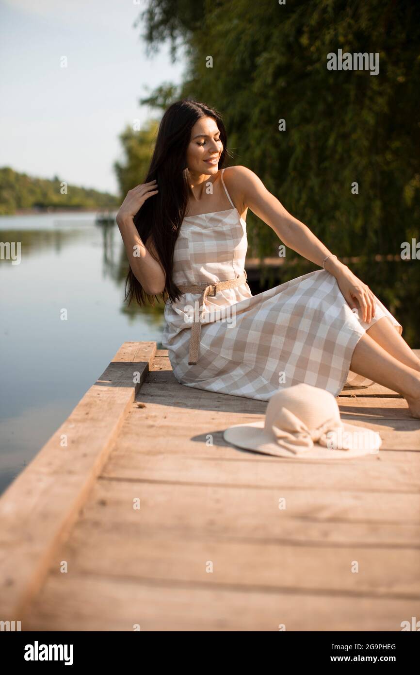 relaxing young woman on wooden pier at the calm lake Stock Photo - Alamy