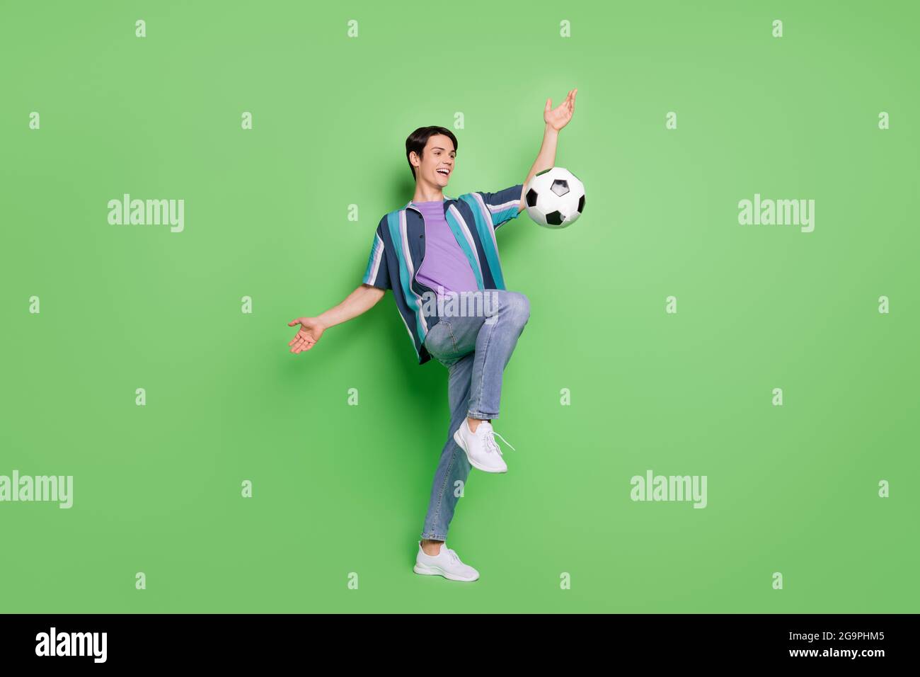 Full size photo of cheerful young positive active man play football ...