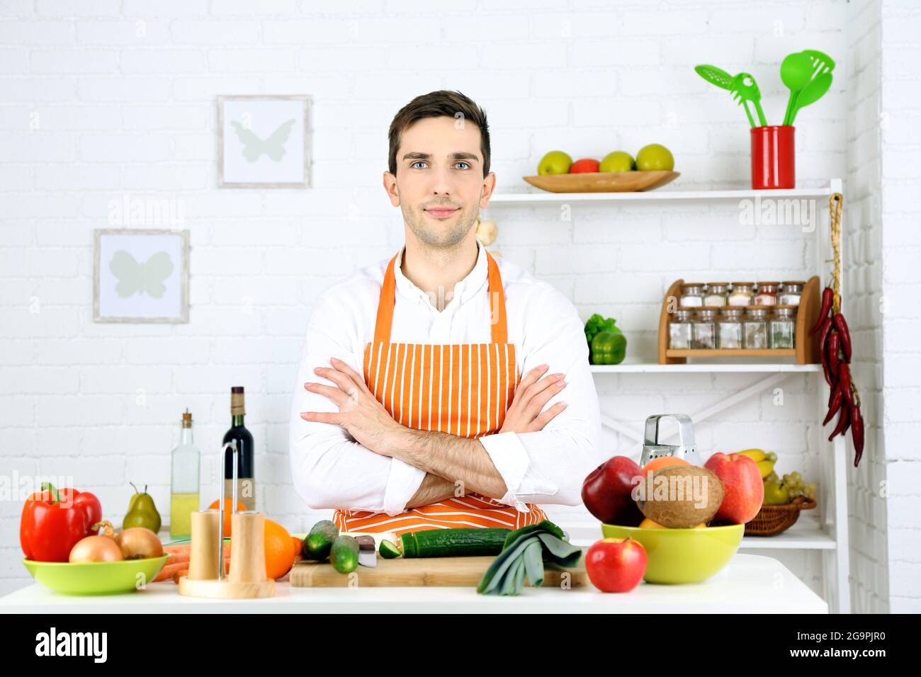 Man at table with different products and utensil in kitchen on white ...