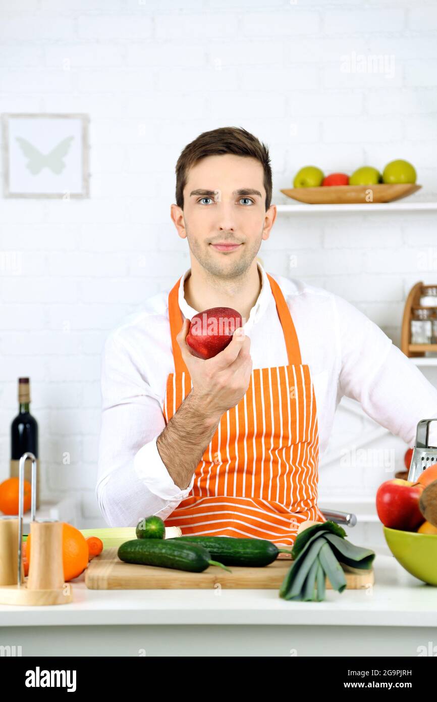 Man at table with different products and utensil in kitchen on white ...
