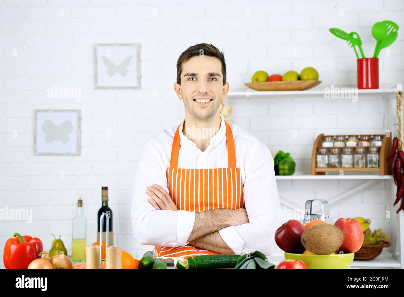 Man at table with different products and utensil in kitchen on white ...