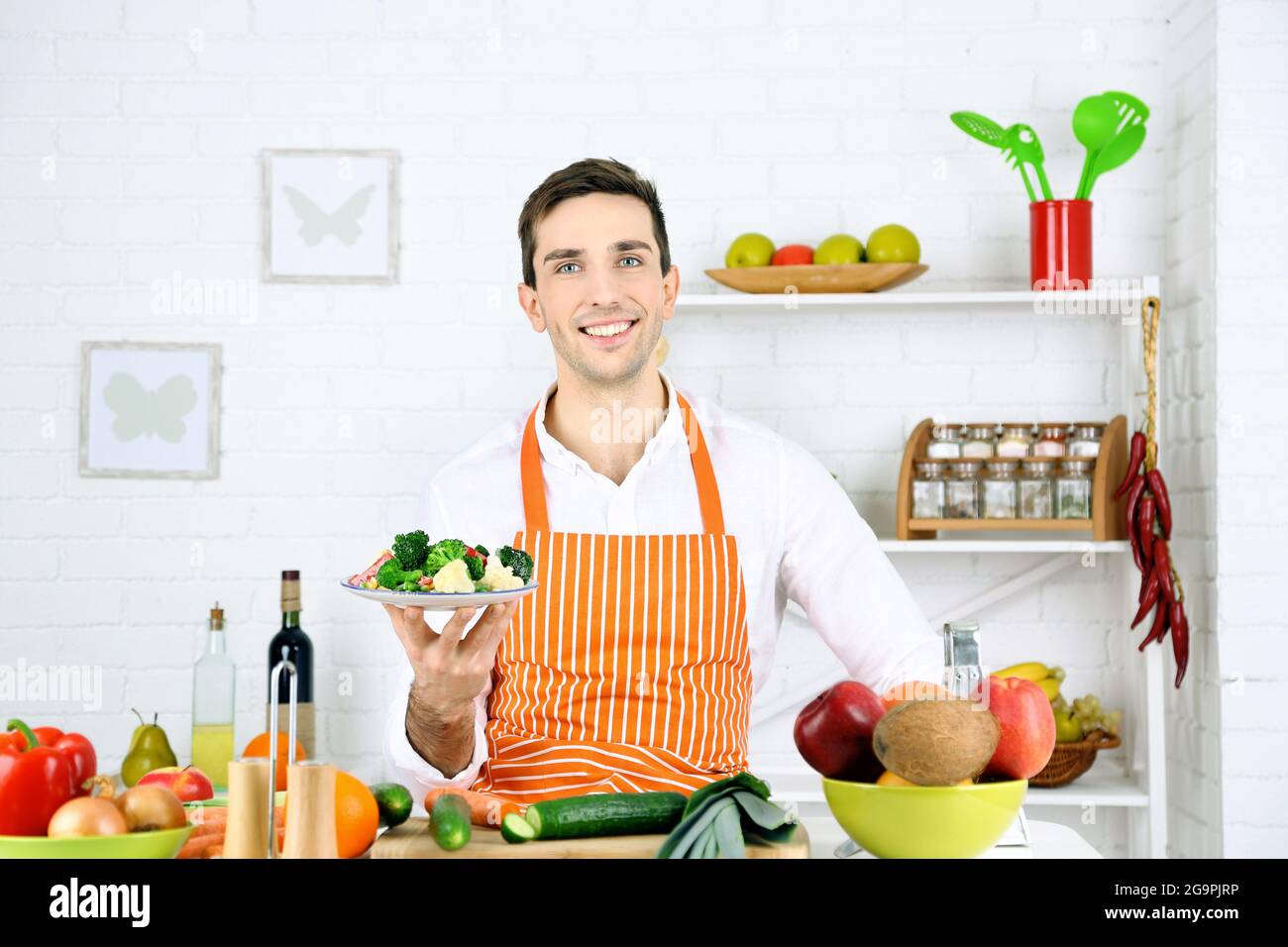 Man at table with different products and utensil in kitchen on white ...
