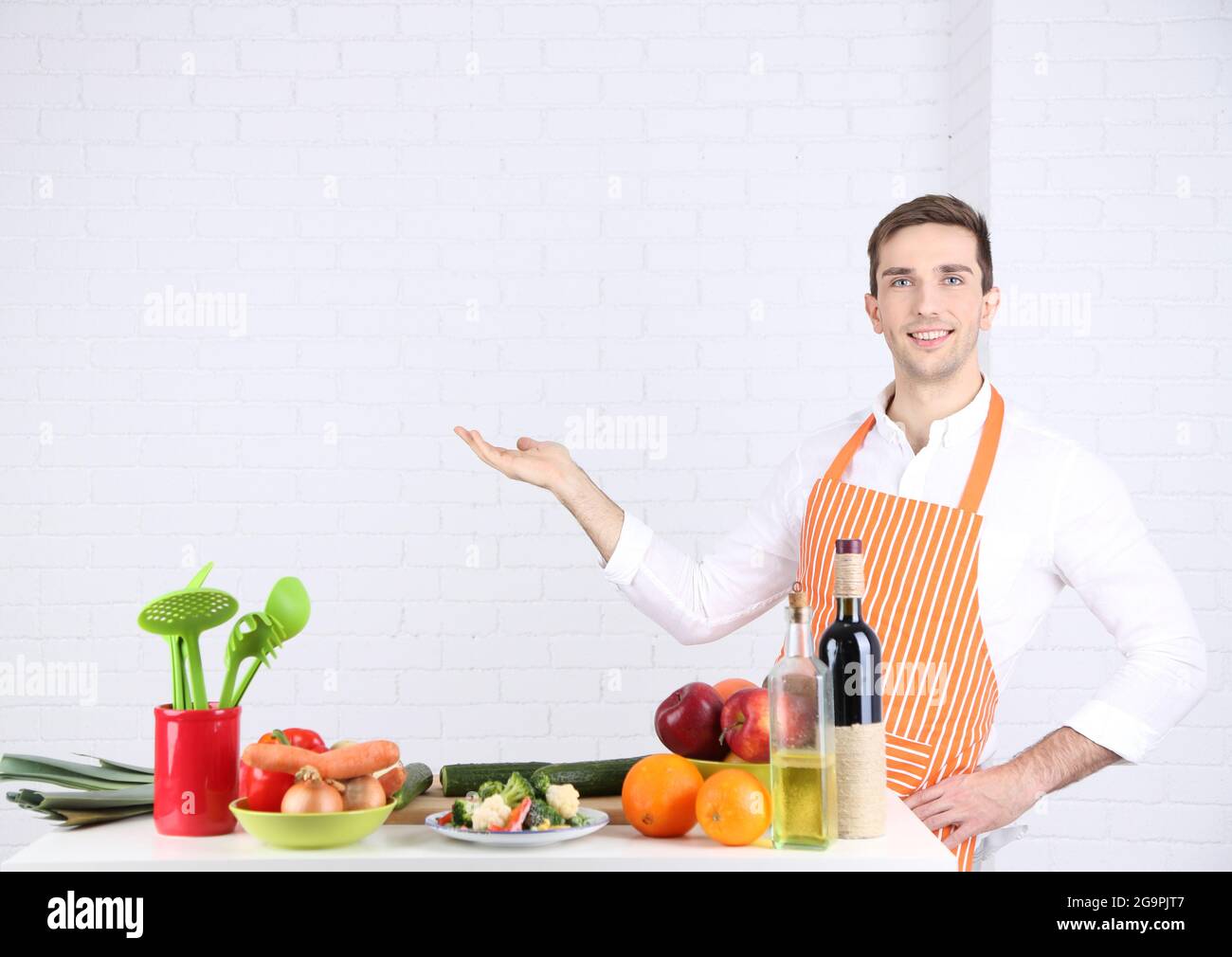 Man at table with different products and utensil in kitchen on white ...
