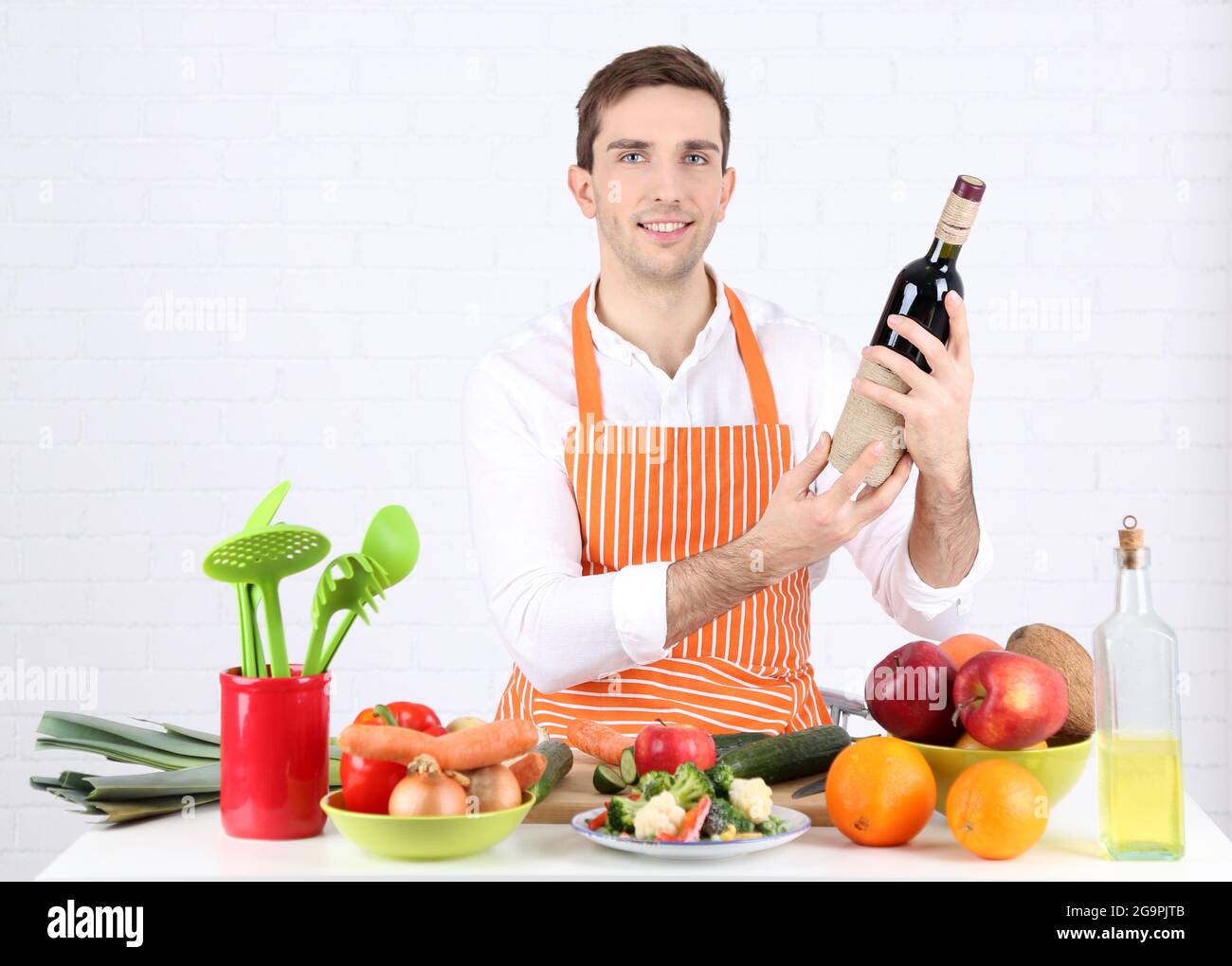 Man at table with different products and utensil in kitchen on white ...