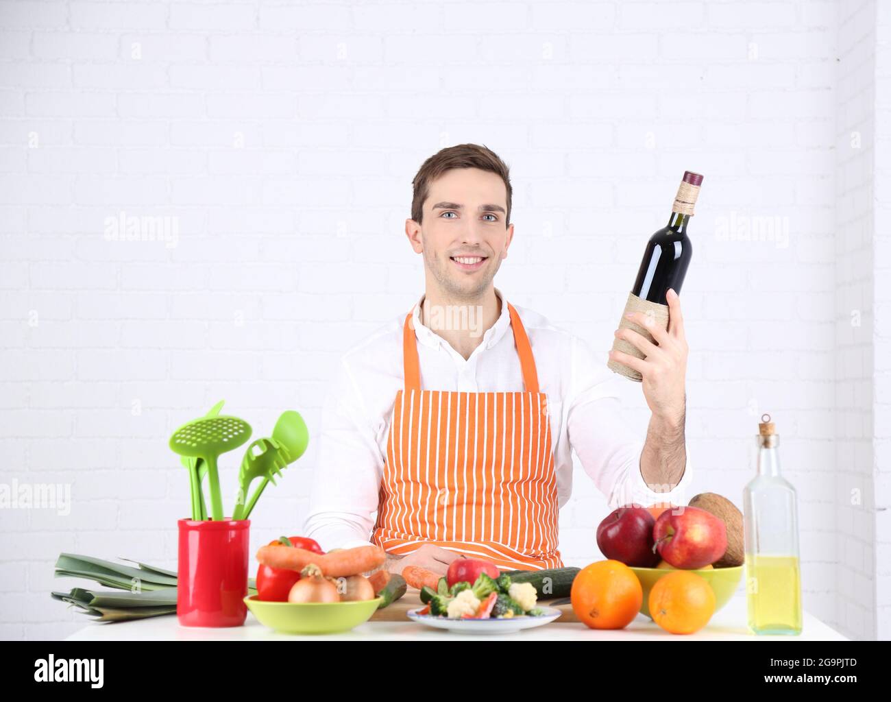 Man at table with different products and utensil in kitchen on white ...