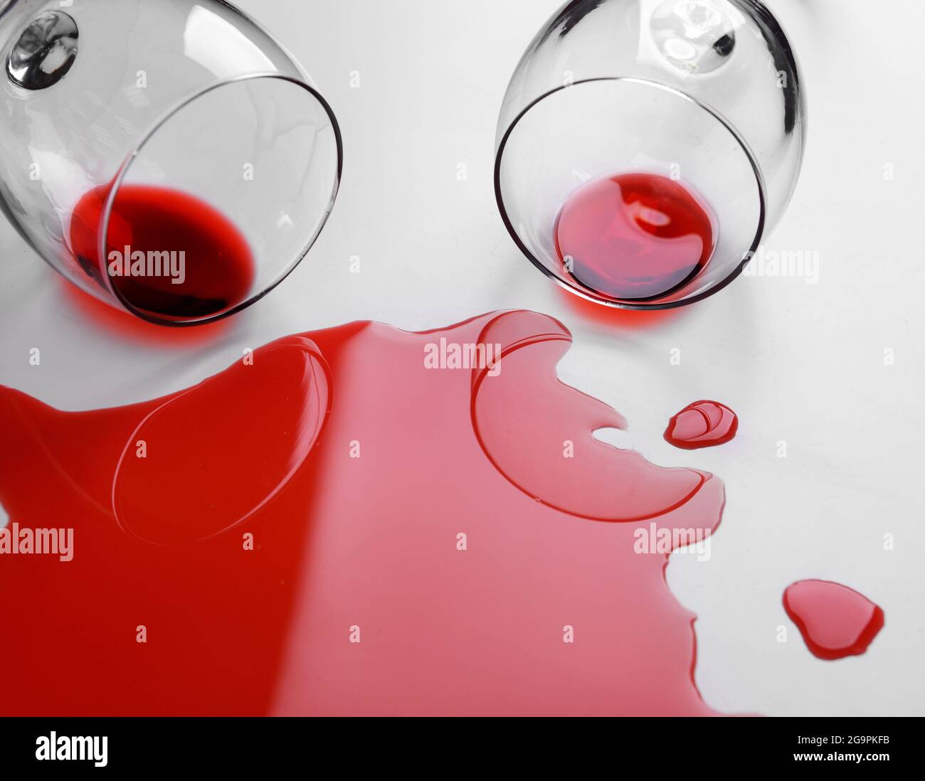 Red wine spilled from glass on white background Stock Photo - Alamy