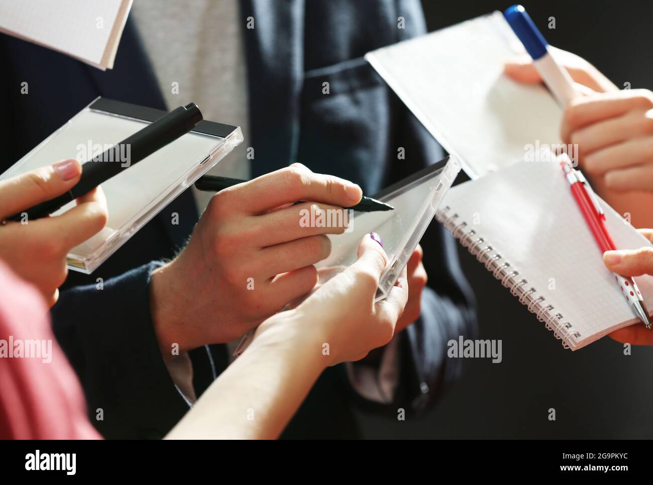 Elegant man signing autograph in notebook on dark background Stock ...
