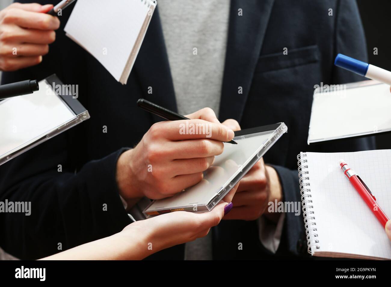 Elegant man signing autograph in notebook on dark background Stock ...