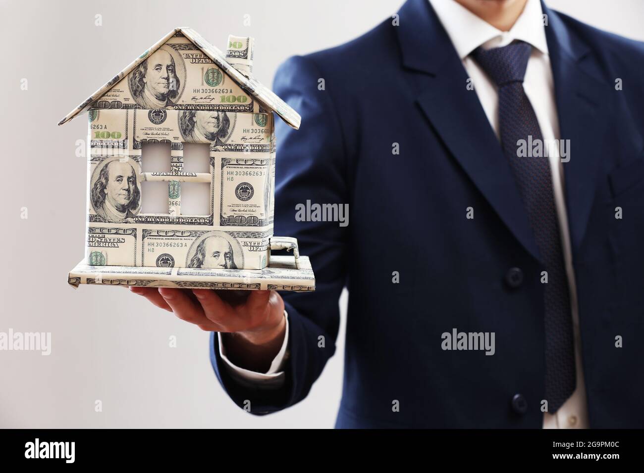 Model of house made of money in male hand on white background Stock ...