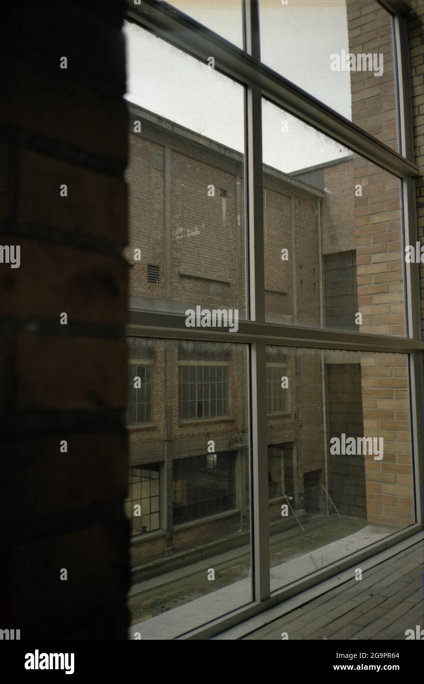 Vertical shot of big old windows of an aged brick building on a gloomy ...