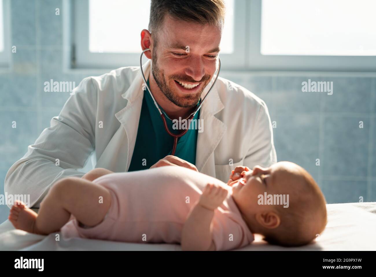 Happy pediatrician doctor with baby checking possible heart defect ...