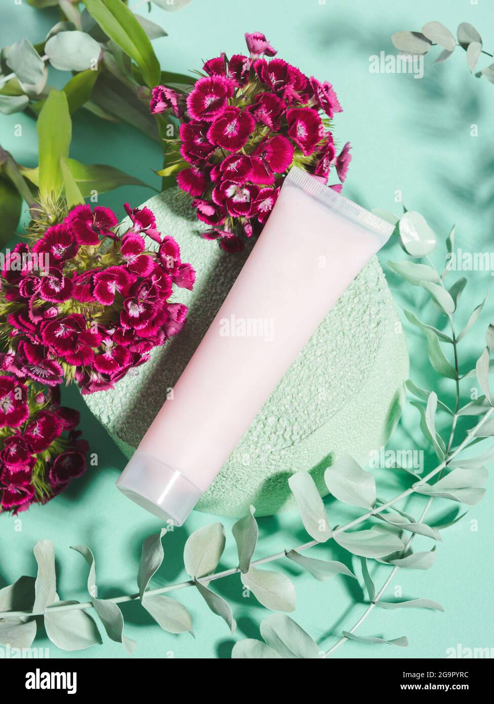 White generic cream tube on green podium with pink flowers Stock Photo ...