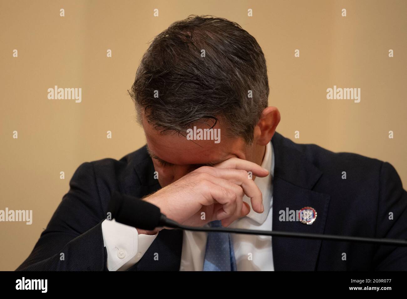 Rep. Adam Kinzinger (R-IL) wipes an eye while watching a video of ...
