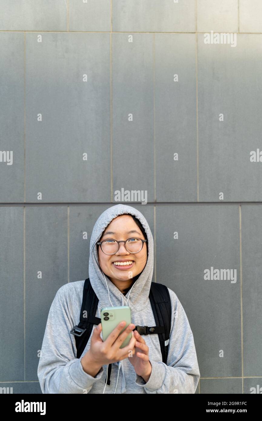 Student holding mobile phone looking at camera Stock Photo - Alamy