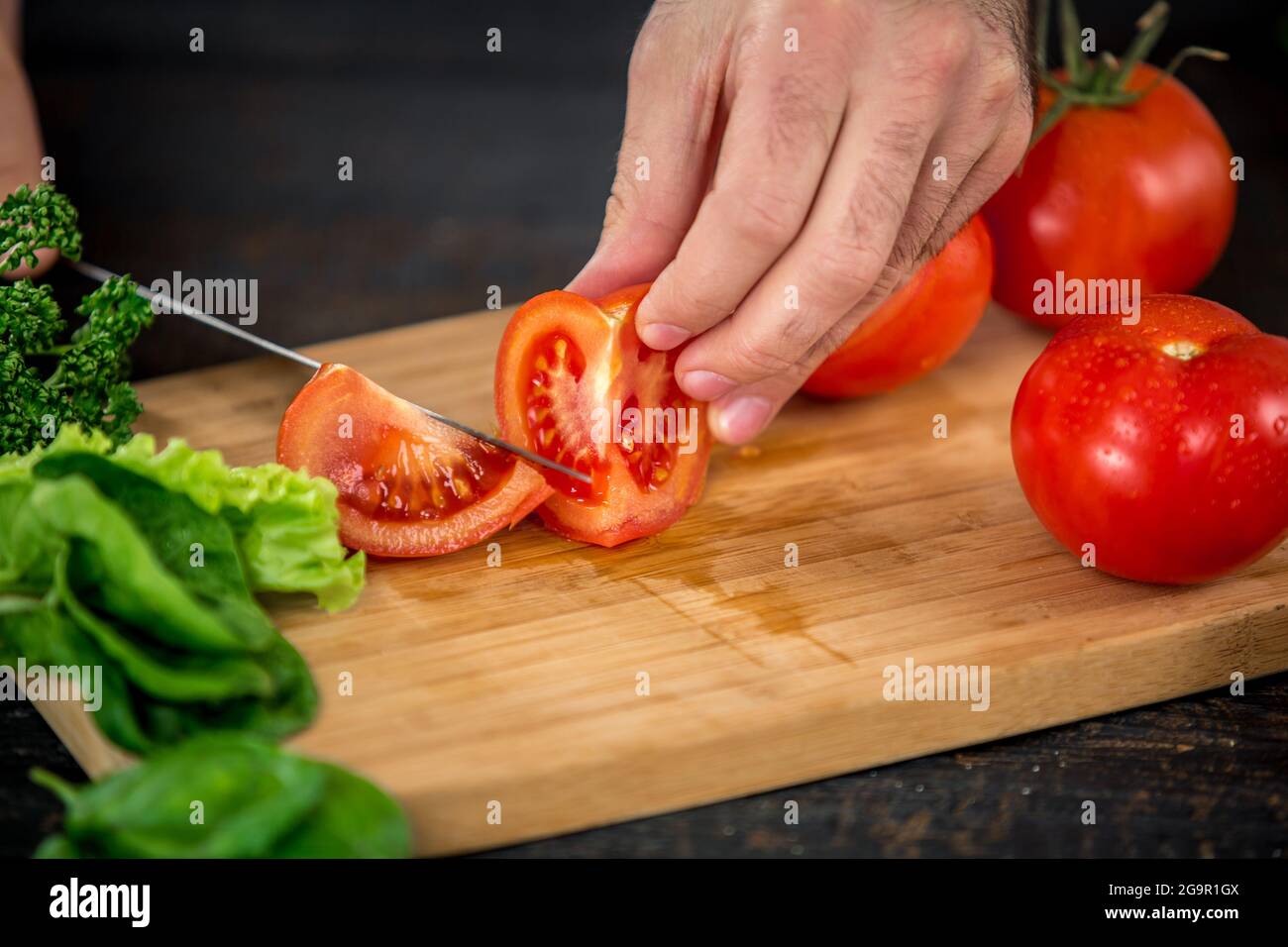 Close up on male hands cutting tomato, making salad. Chief cutting ...