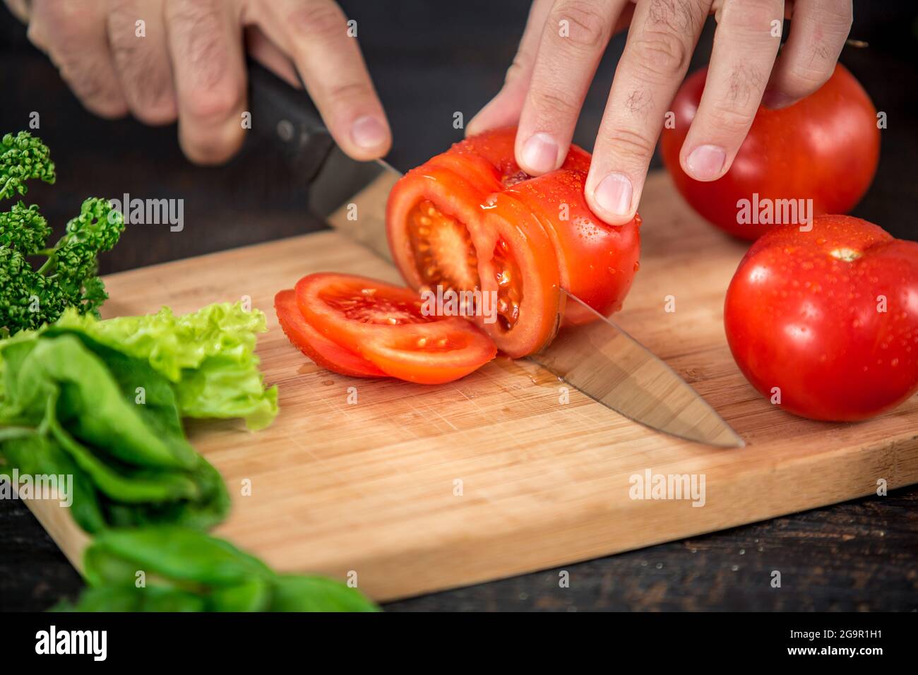 Close up on male hands cutting tomato, making salad. Chief cutting ...