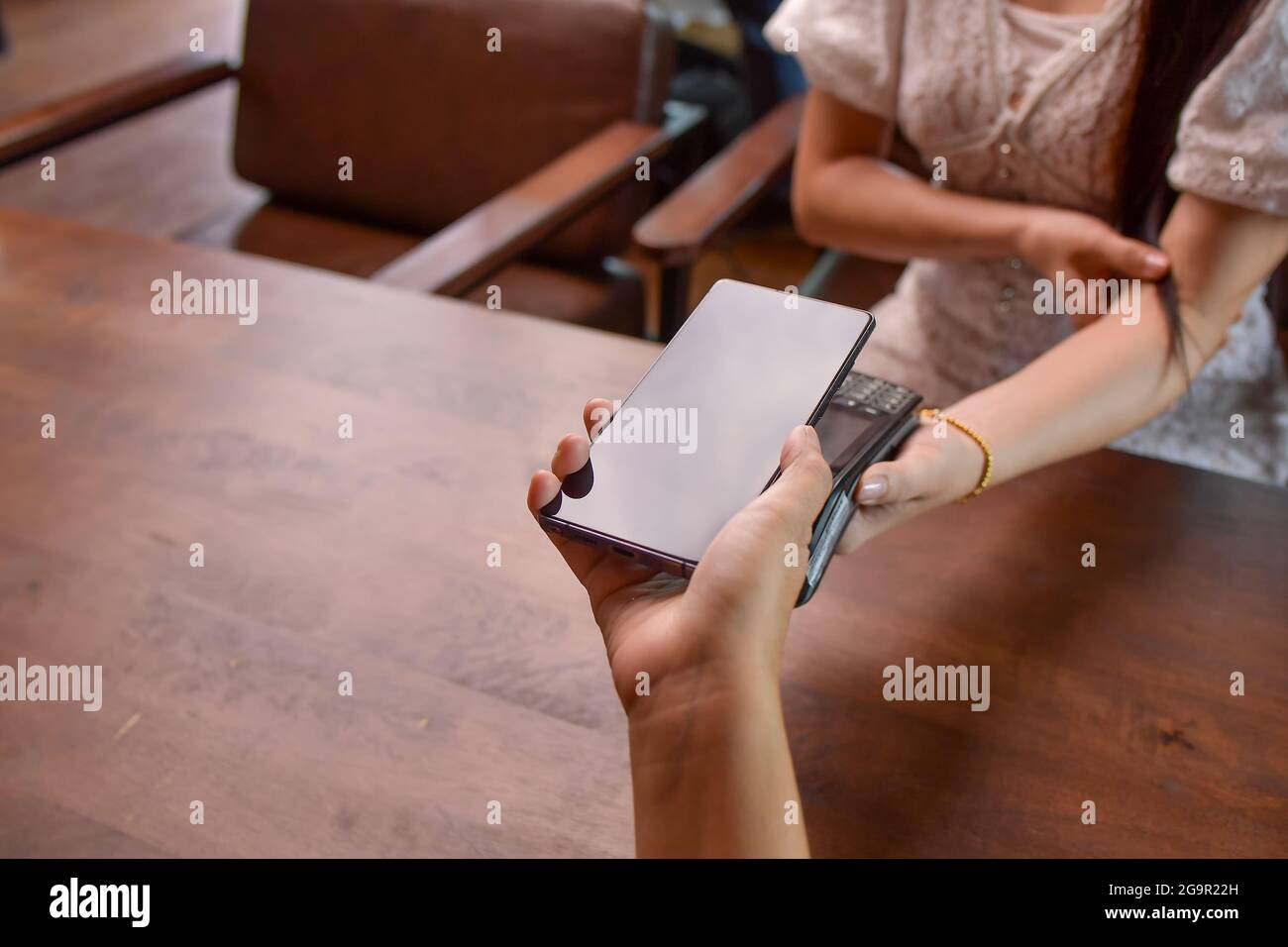 Contactless payment method. Closeup of a customer using her smartphone ...