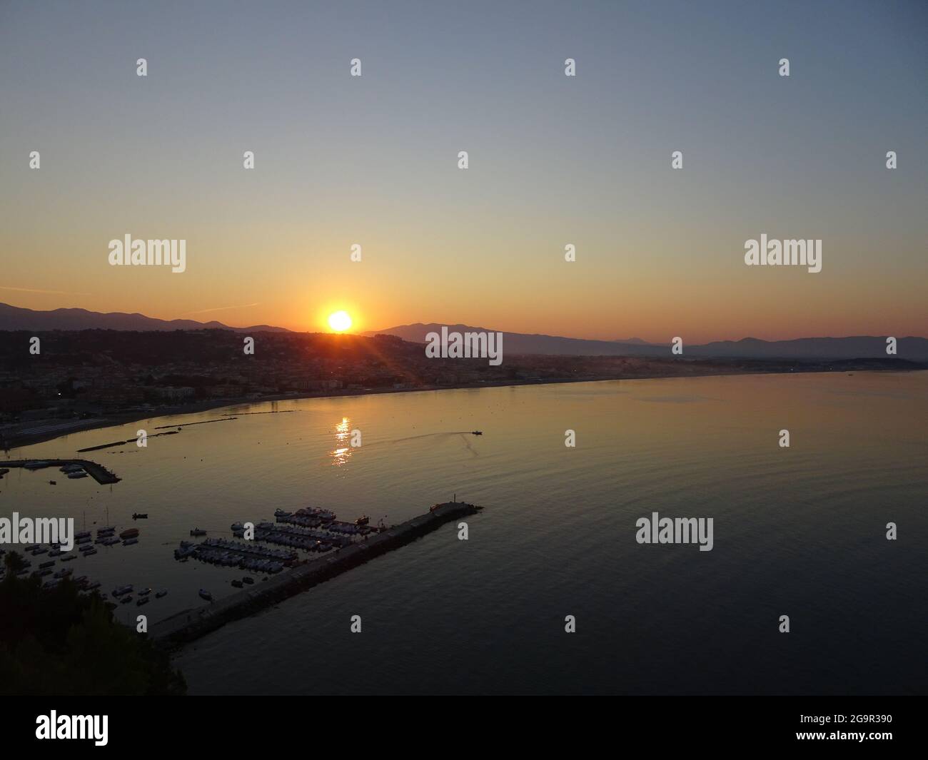 Beautiful view of a sunset in a background of a sea and a small boat ...