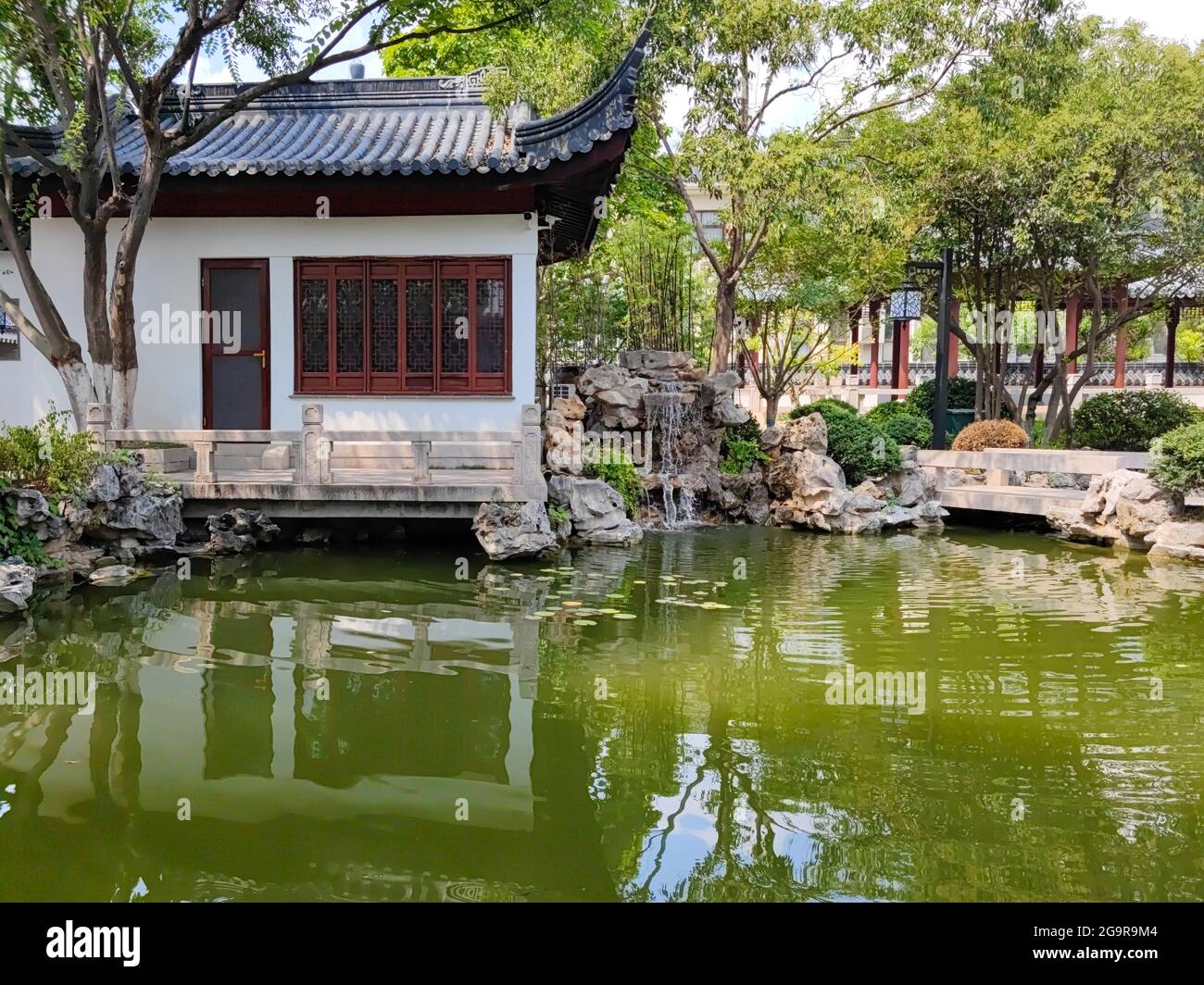 Chinese classical courtyard with small bridge and water Stock Photo - Alamy