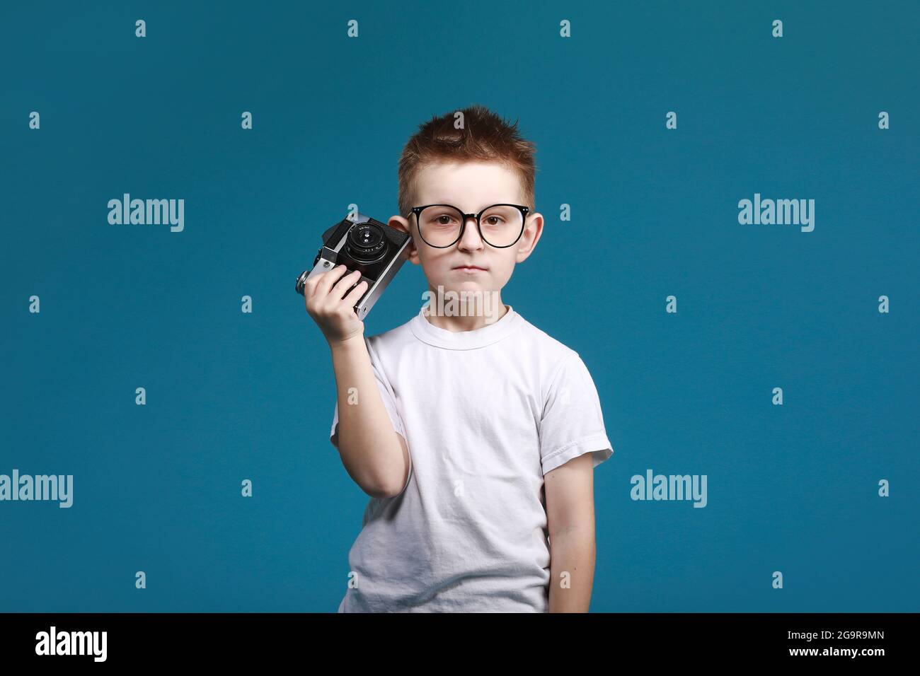 Little boy taking a picture using a retro camera. Child boy with ...