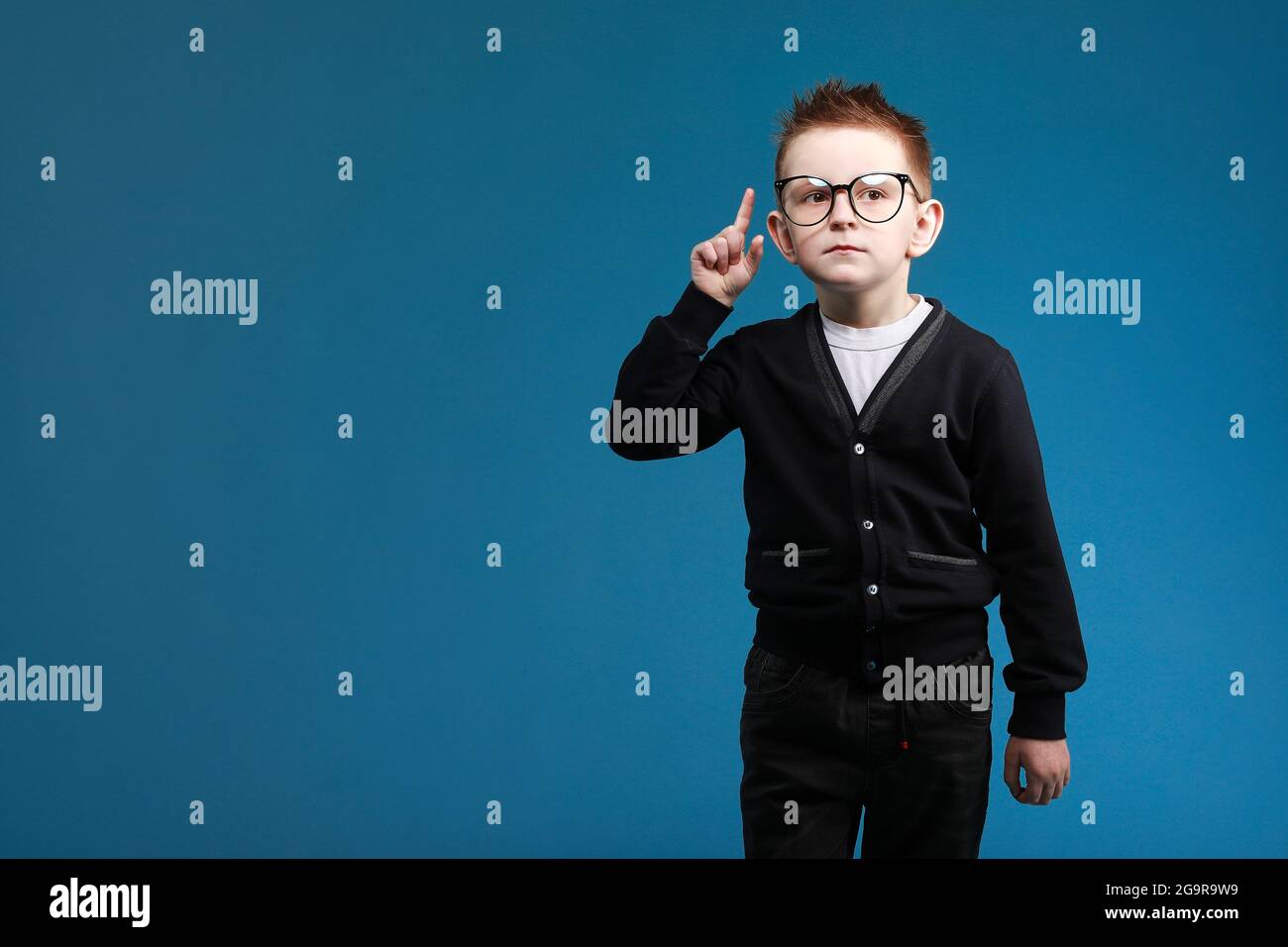 eureka, handsome little boy in glasses is surprised, inspired, I have an idea, Raise your index ...
