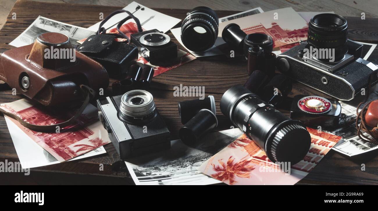 Old outdated photo cameras, lenses and exposure meters on wooden ...
