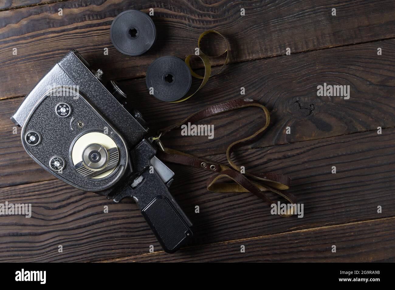 Old amateur movie camera and spools of roll film on wooden background ...