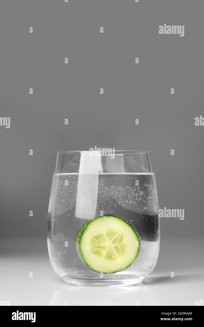 Glass with fresh cucumber on grey background Stock Photo - Alamy