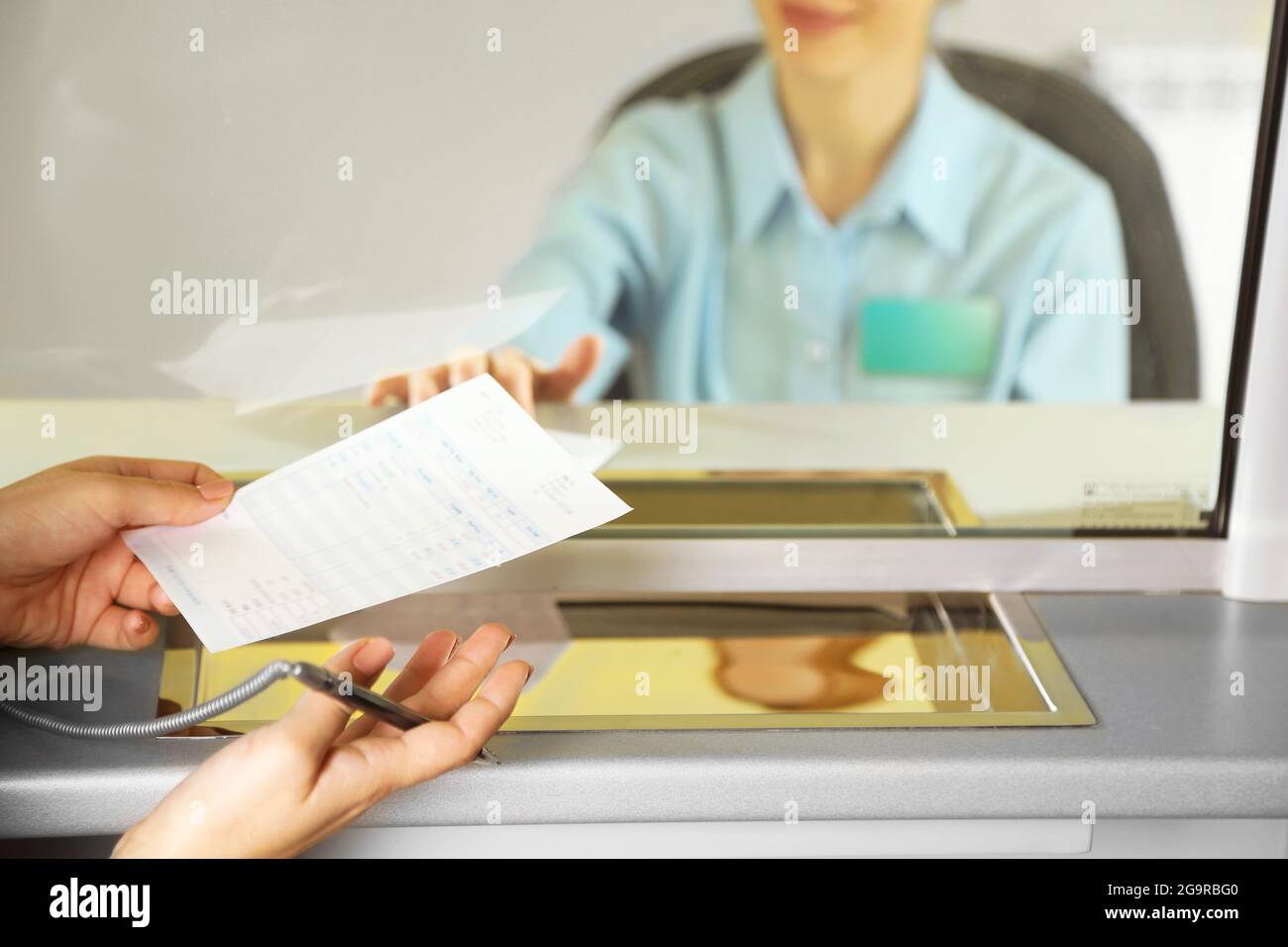Teller window with working cashier Stock Photo - Alamy