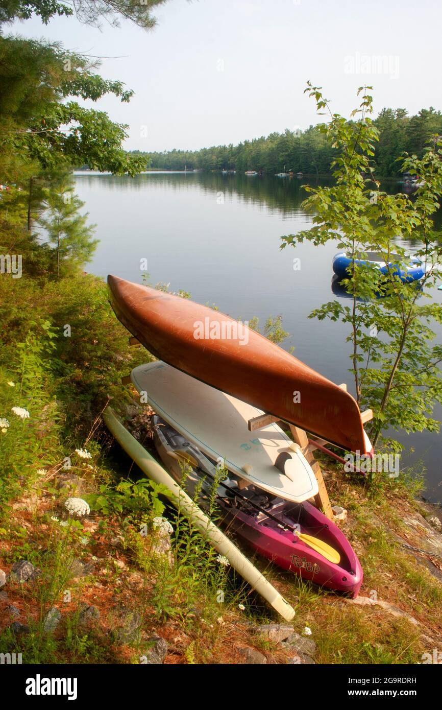 A canoe sits along the shoreline of a Muskoka, Ontario lake Stock Photo ...