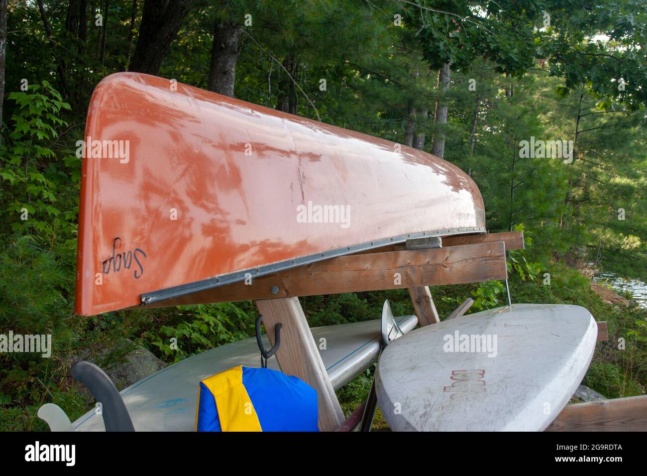 Canoe and paddle boards on a boat rack Stock Photo - Alamy