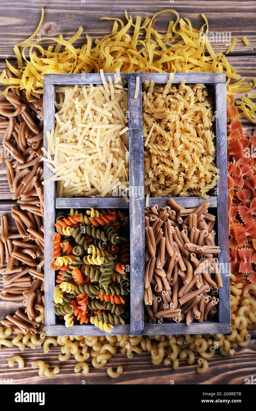Different types of pasta in box on wooden background Stock Photo - Alamy